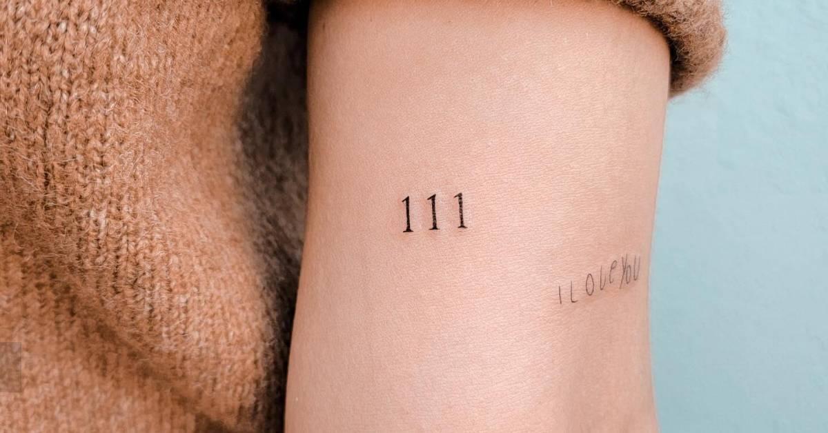 Angel number "111" tattooed on the inner arm.