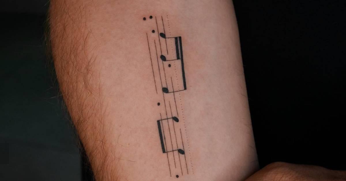 Music staff tattoo located on the inner forearm.