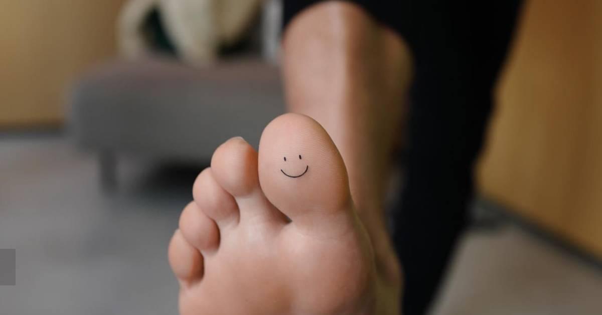 Minimalistic style smiley face tattoo located on the