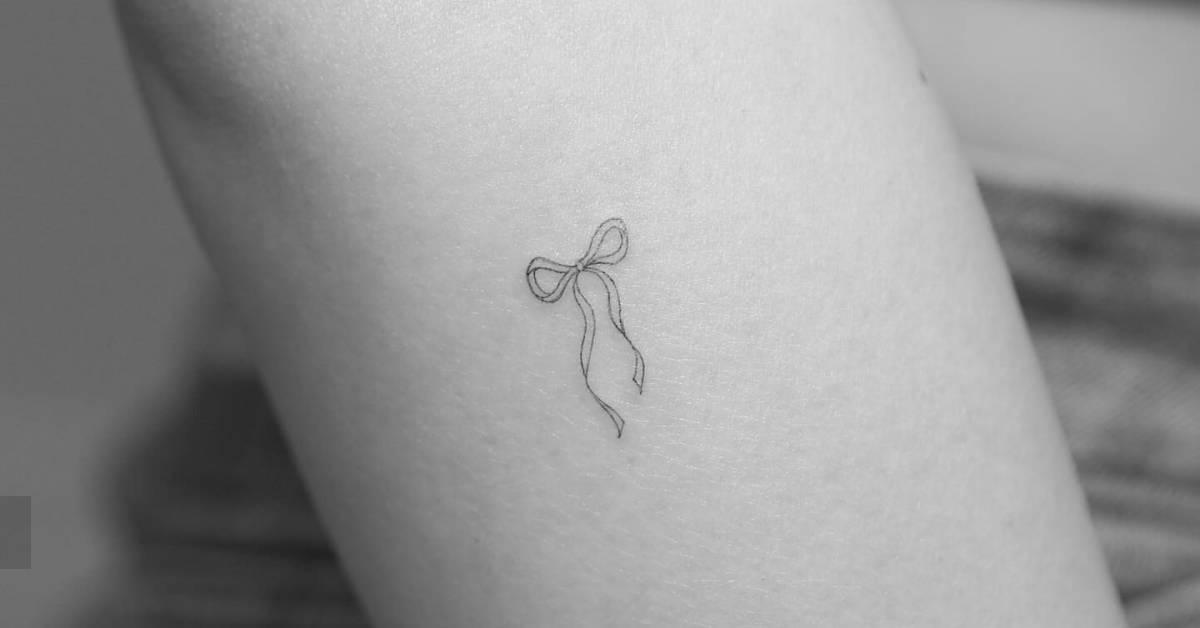 Ribbon tattoo in fine line style located on the
