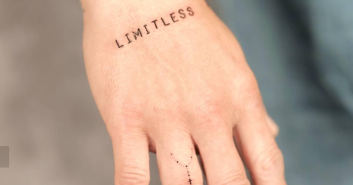 Tattoos of the word "limitless" and rosary located on