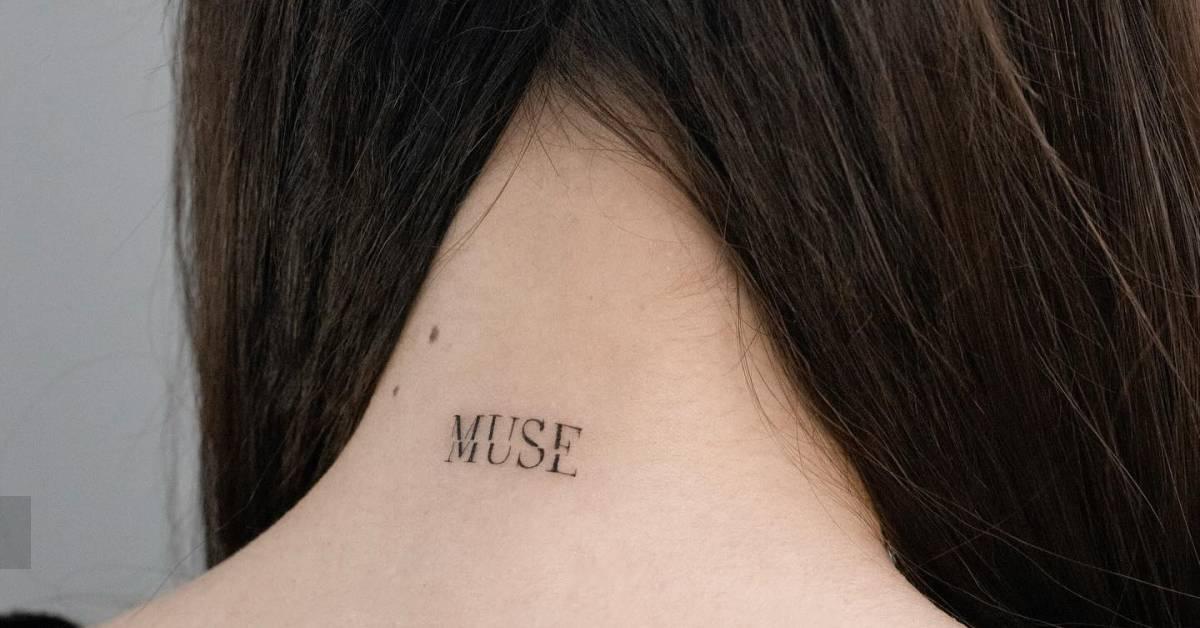 Lettering tattoo of the word "muse" located on the back