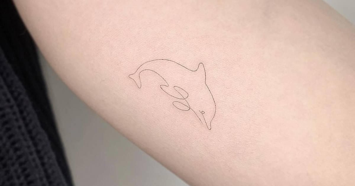 One line dolphin tattoo placed on the inner forearm.