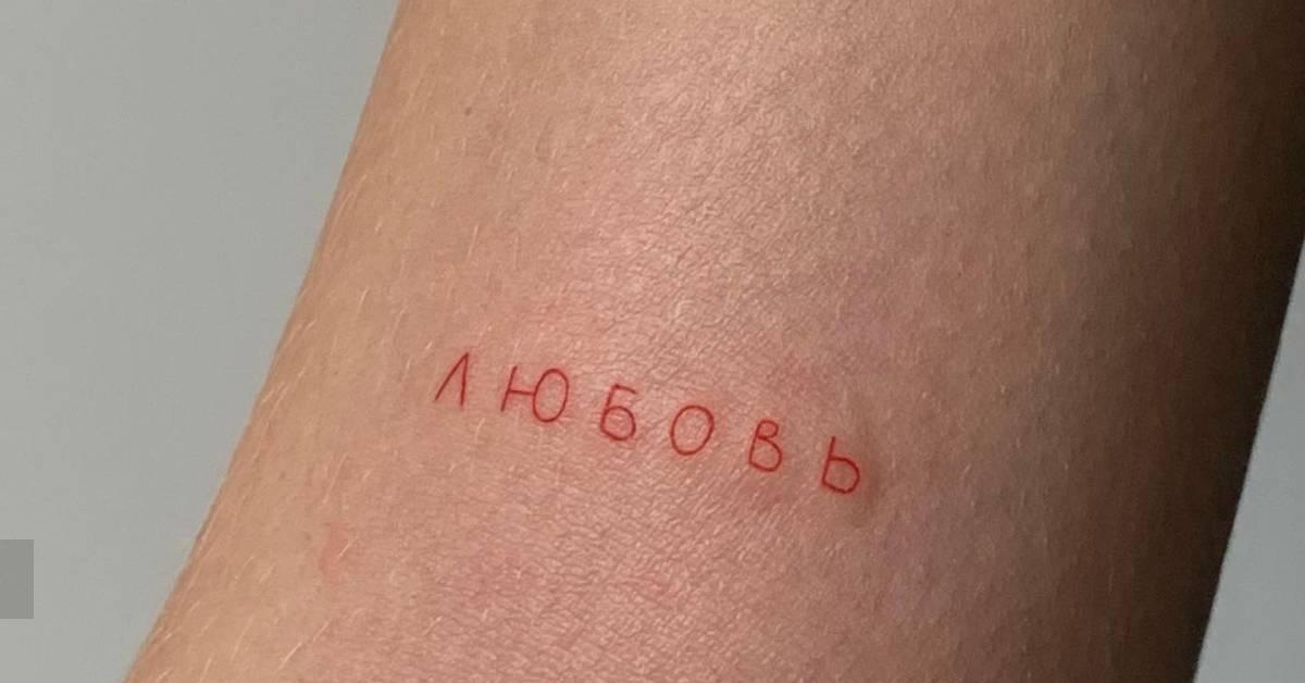 Russian lettering tattoo in red ink located on the