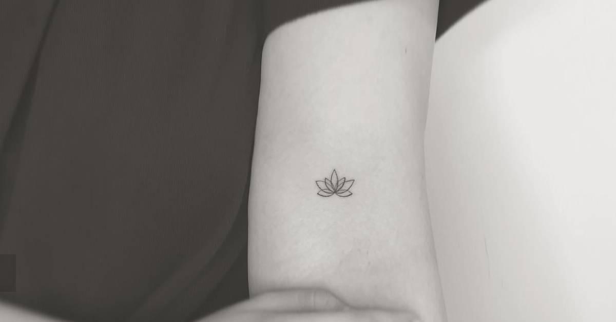 Minimalistic little lotus flower tattoo located on the