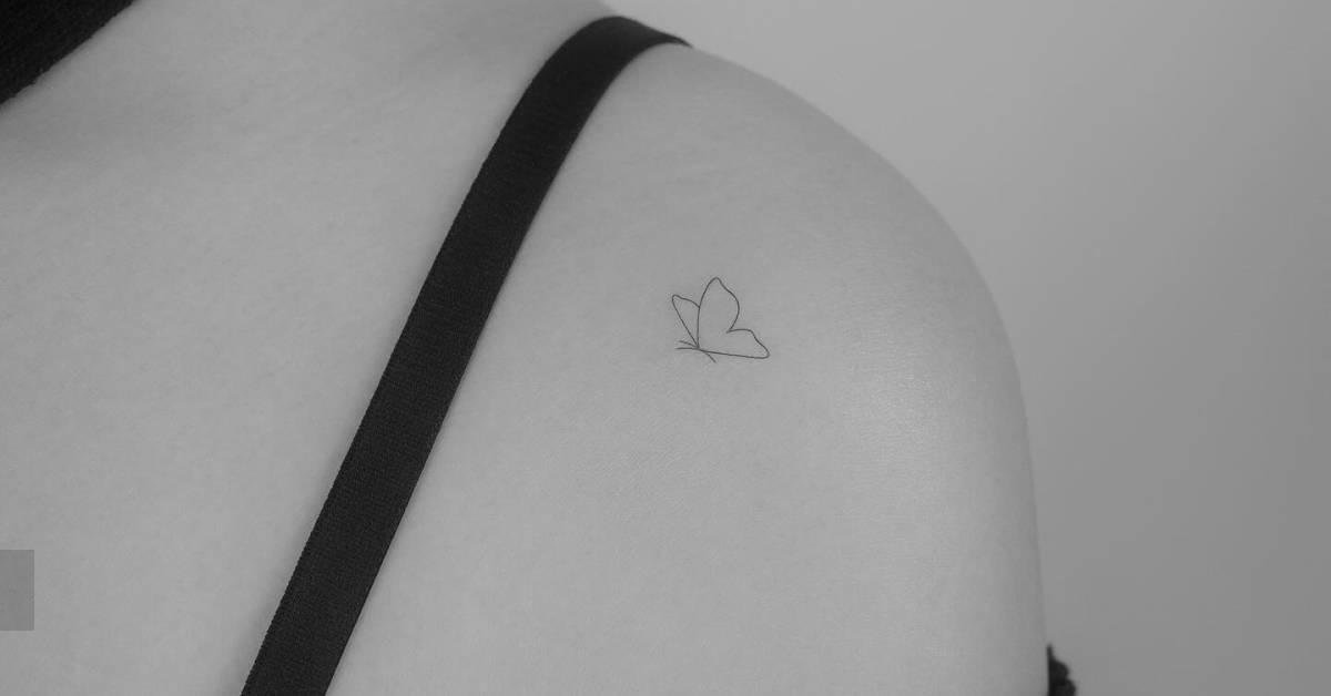 Fine line style minimalistic butterfly tattooed on the