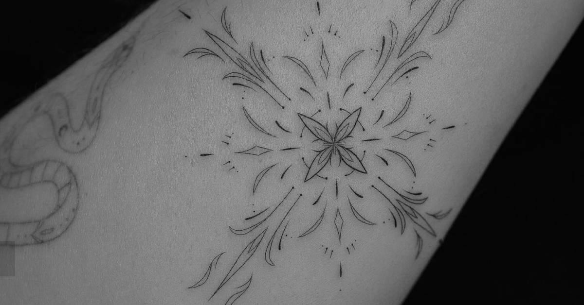 Fine line style ornamental tattoo placed on the