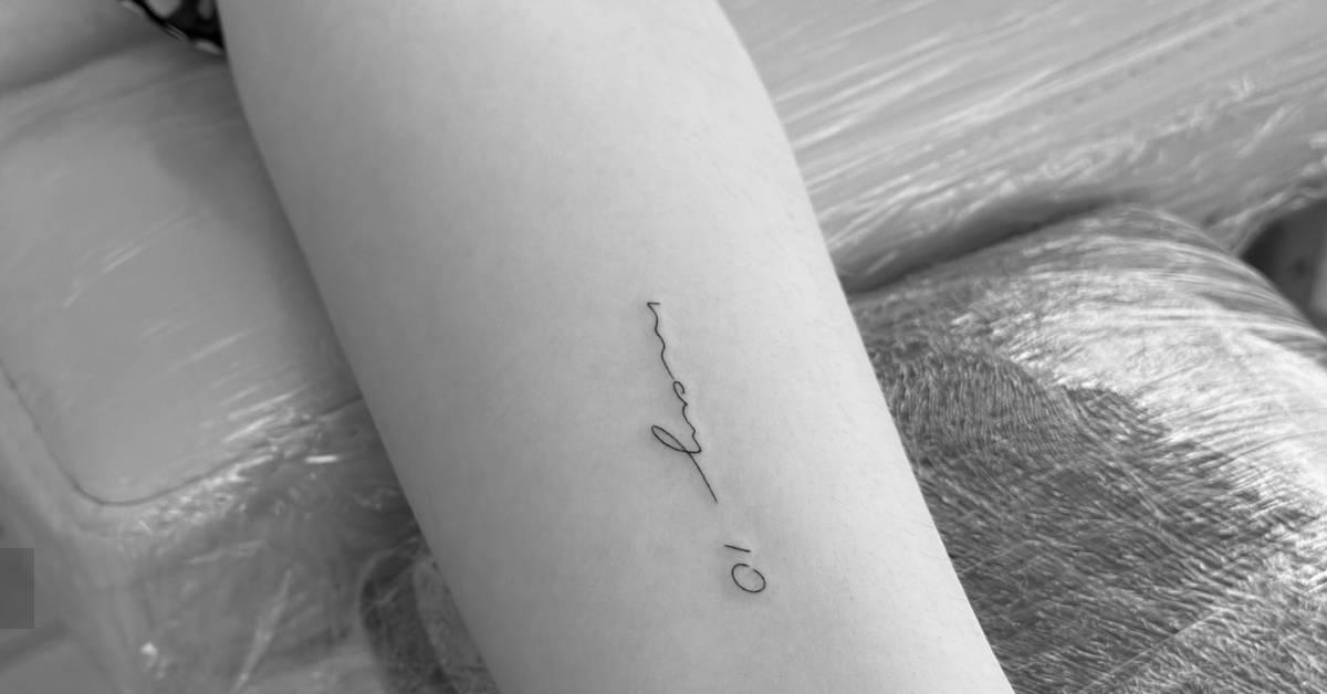 "May 10" lettering tattoo located on the inner forearm.