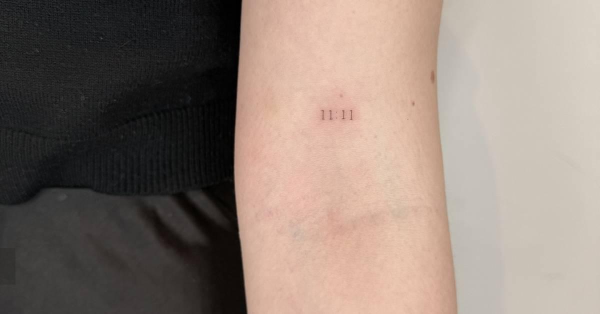 Angel number "11:11" lettering tattoo located on the