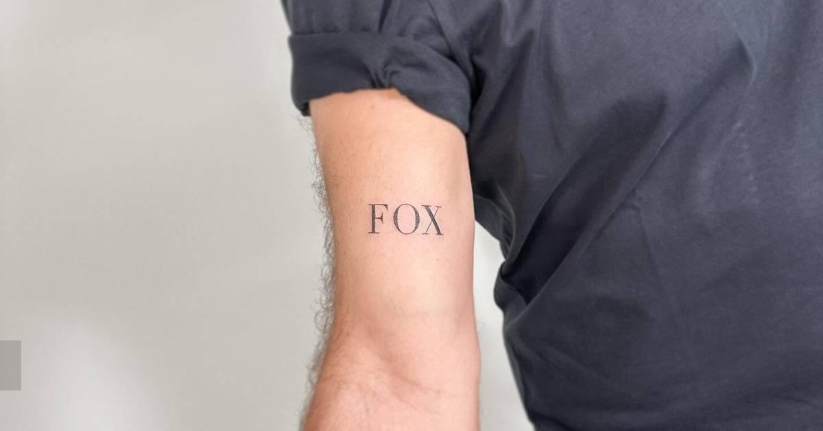 "Fox" lettering tattoo in serif font located on the