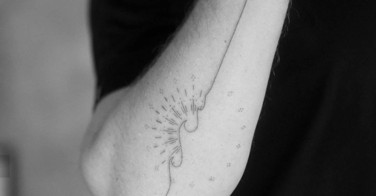 Fine line style sun and wave tattoo located on the