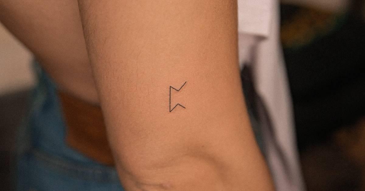 Minimalistic style Perthro rune tattoo located on the