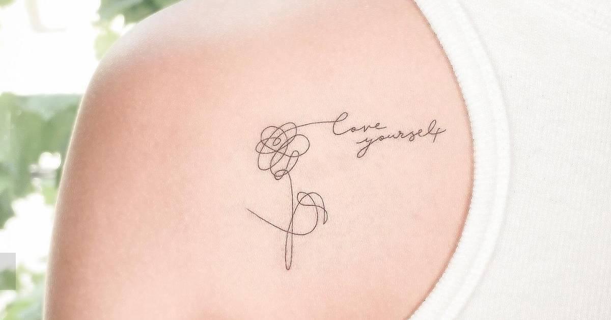 "Love yourself" and one line rose tattoo located on the