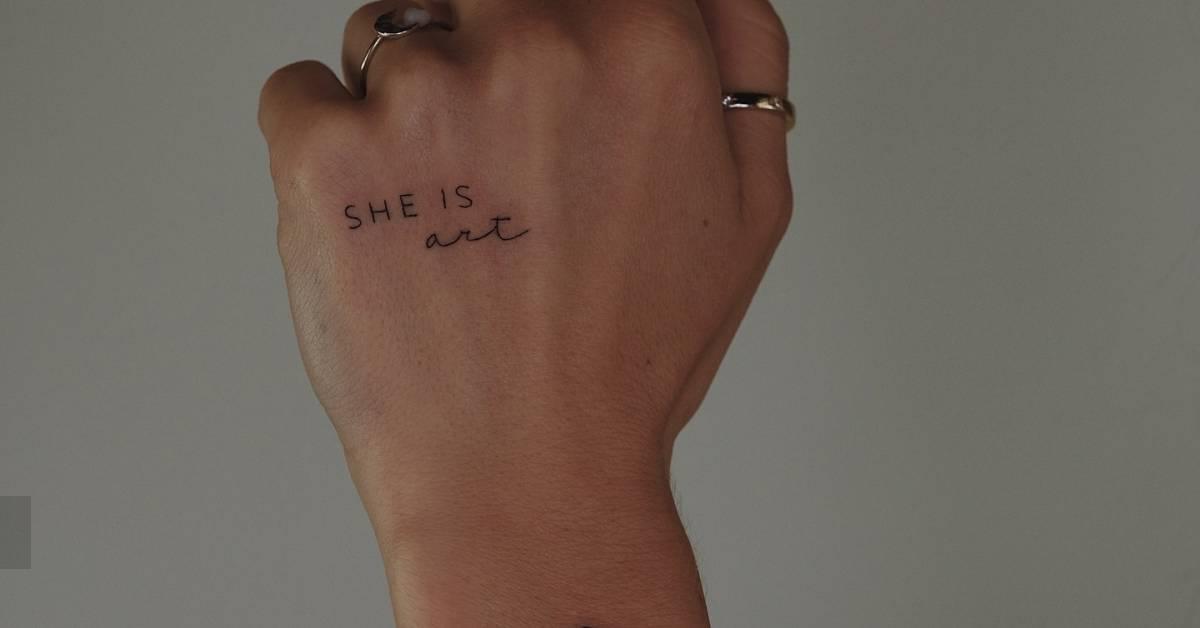 Handwritten "she is art" and ornament tattoos.