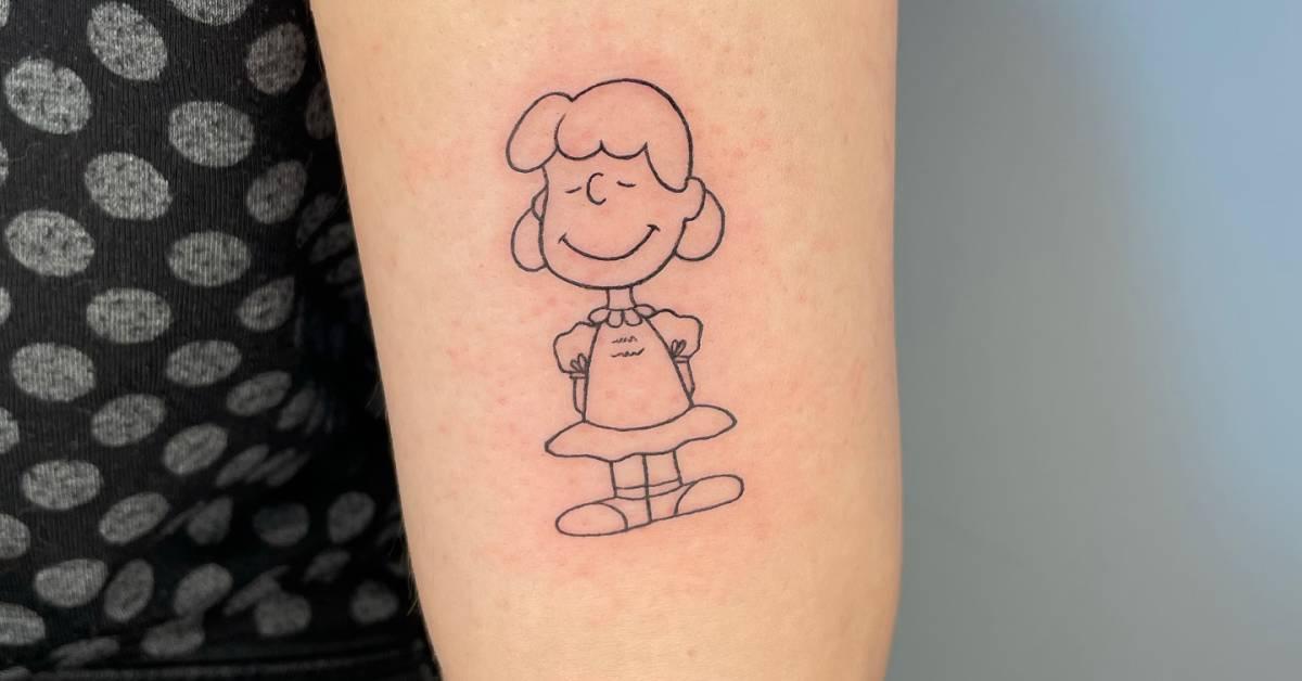 Lucy Van Pelt tattoo located on the tricep.