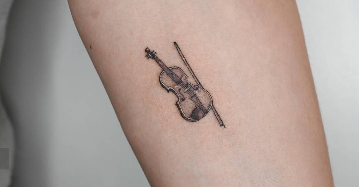 Micro-realistic style violin tattoo located on the