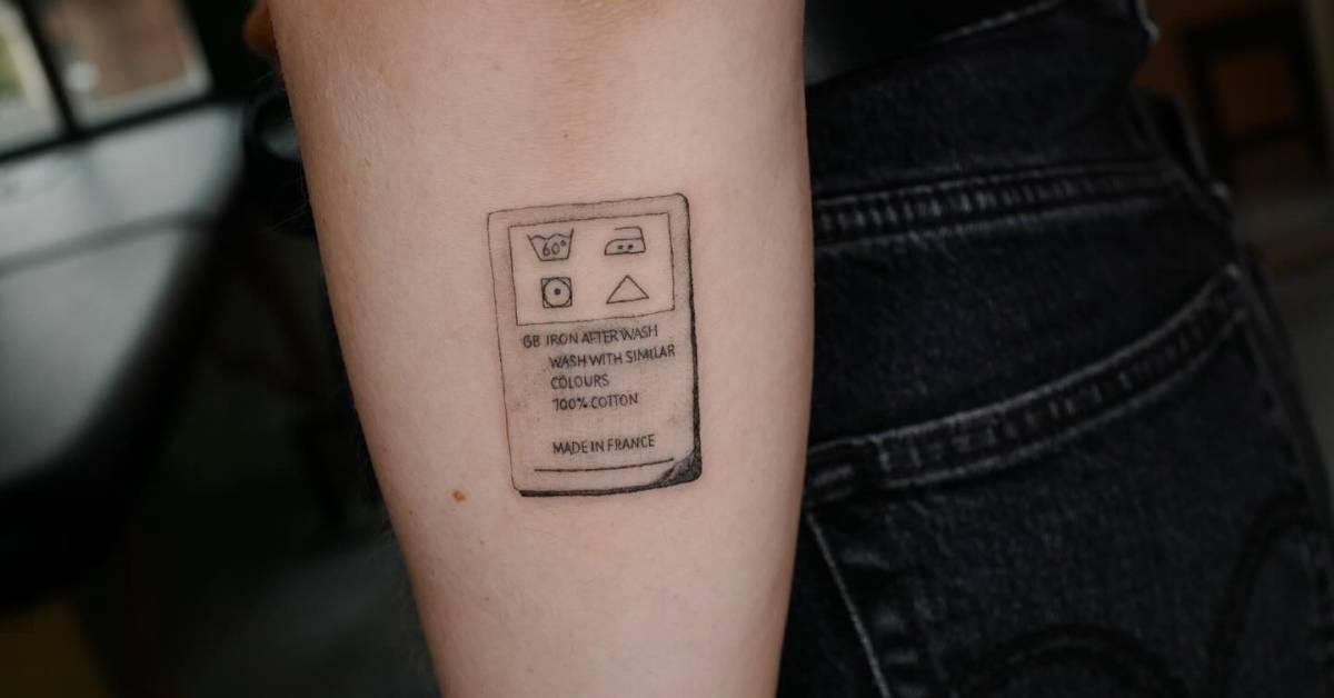 Washing instructions tattoo located on the forearm.