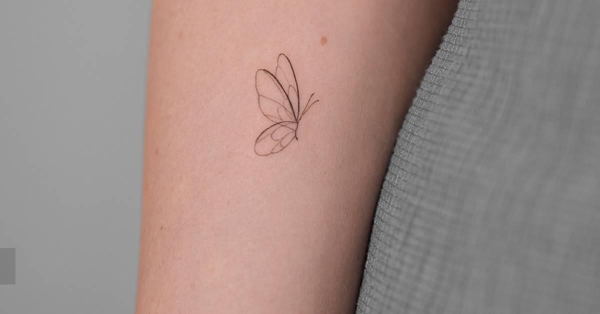 Fine line style butterfly tattoo located on the inner
