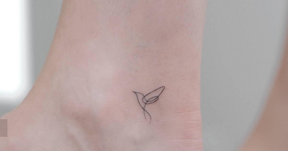 Minimalistic one line hummingbird tattoo located on the