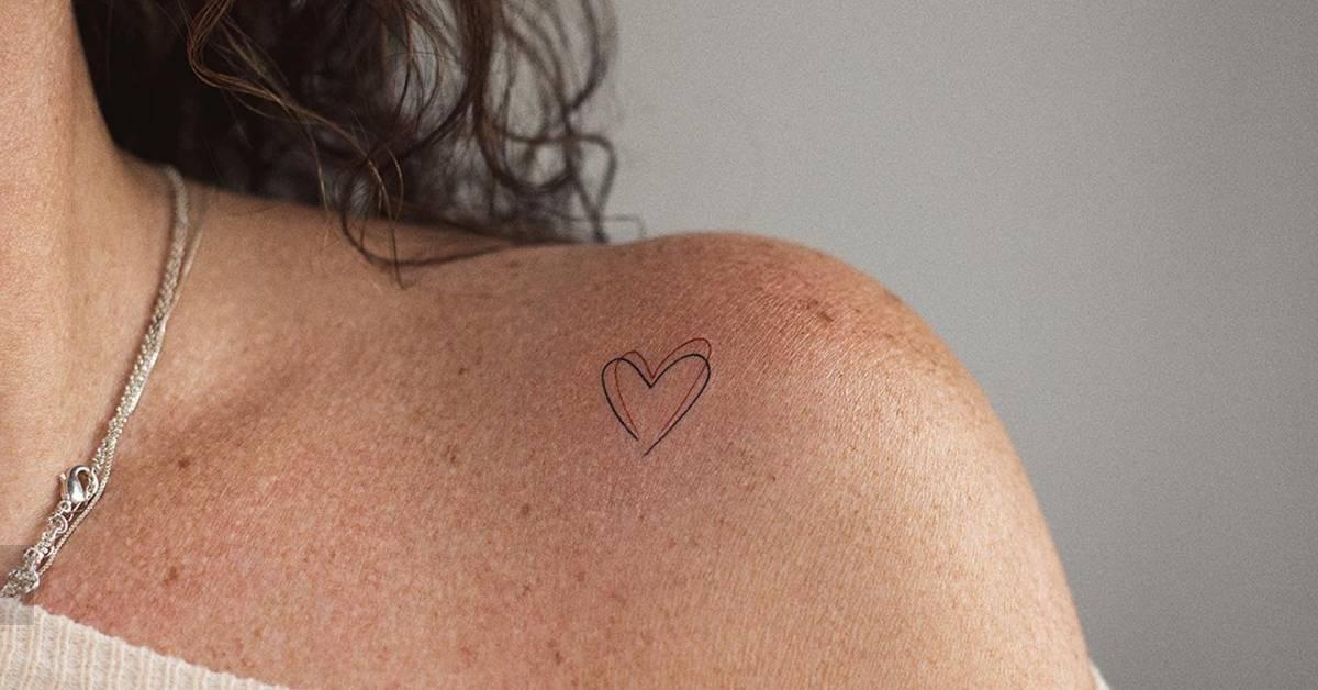 Fine line style heart tattoo placed on the shoulder.