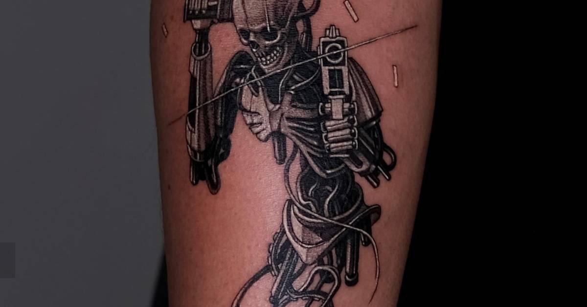 Humanoid robot tattoo located on the inner forearm,
