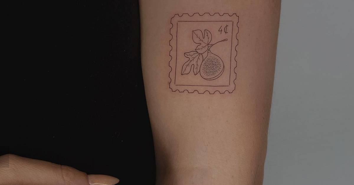 Fine line fig stamp tattoo placed on the upper arm.