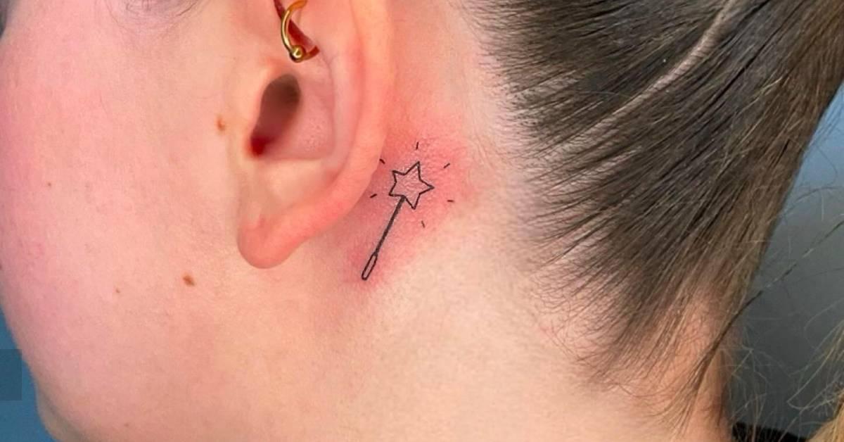 Minimalistic style magic wand tattoo located behind the
