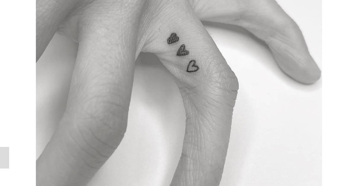 Tiny minimalistic hearts tattooed on the finger.
