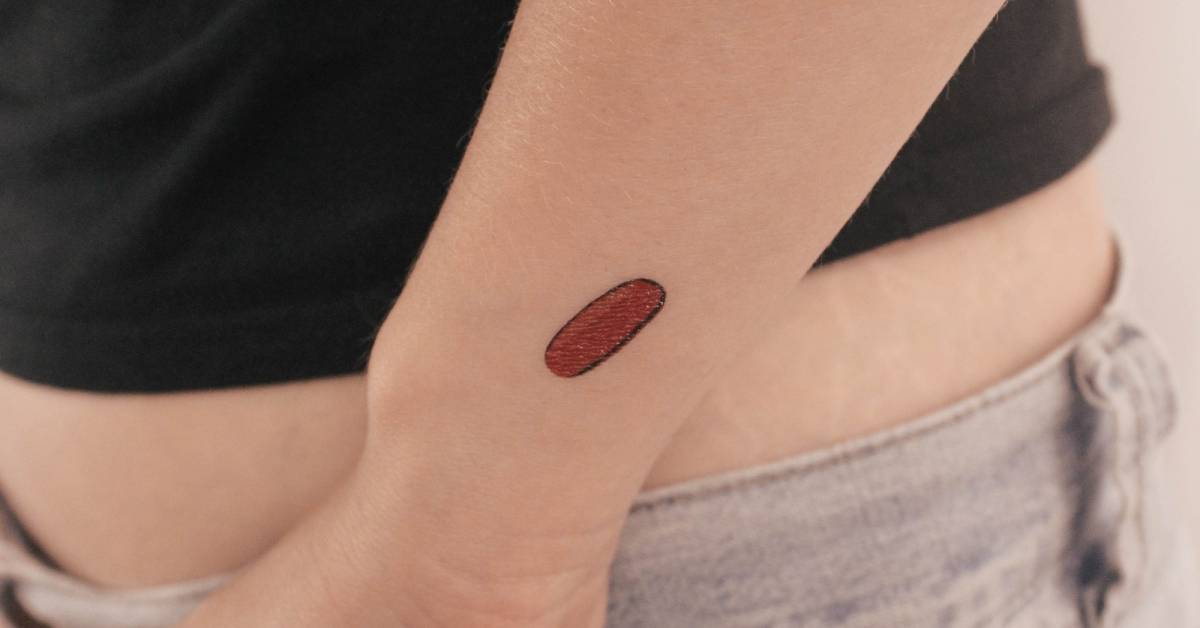 Red pill temporary tattoo located on the wrist.