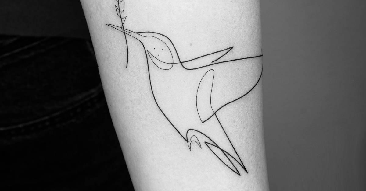 One line hummingbird tattoo located on the forearm.