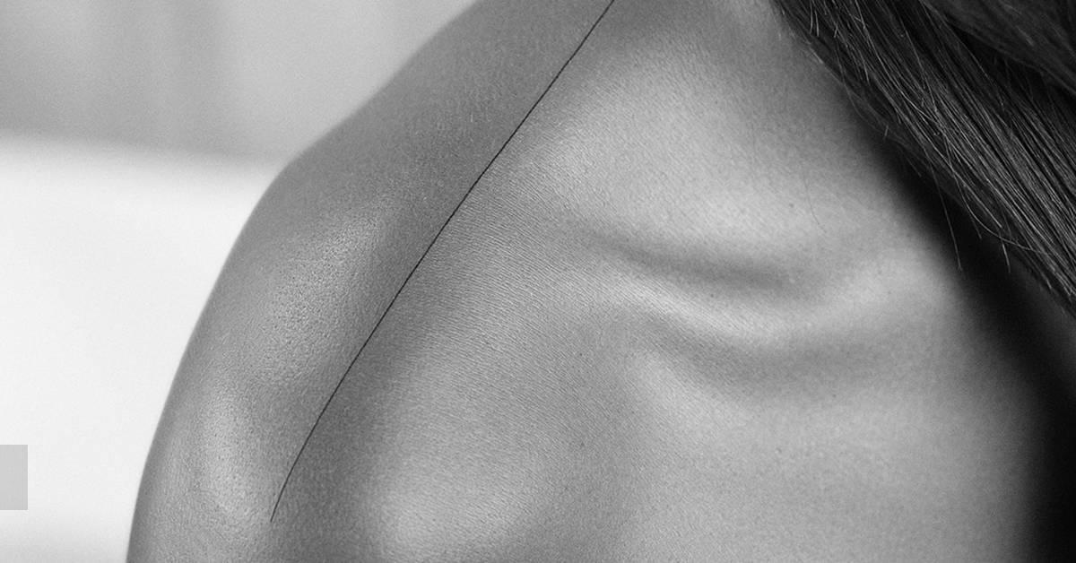Minimalistic line tattoo placed on the top of shoulder.