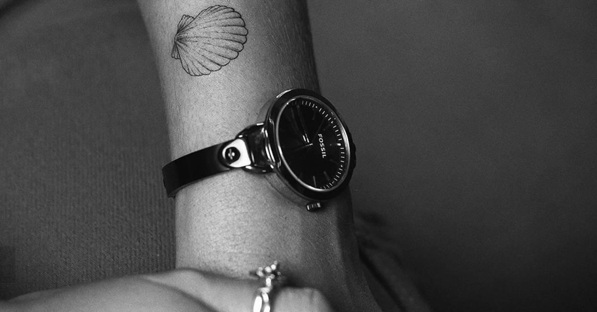 Fine line style scallop shell tattoo located on the