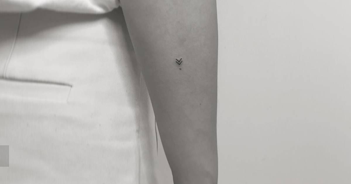 Minimalistic style Kenaz runes tattooed on the forearm.
