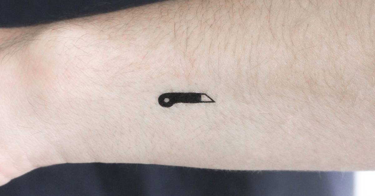 Minimalistic style cutter temporary tattoo placed on