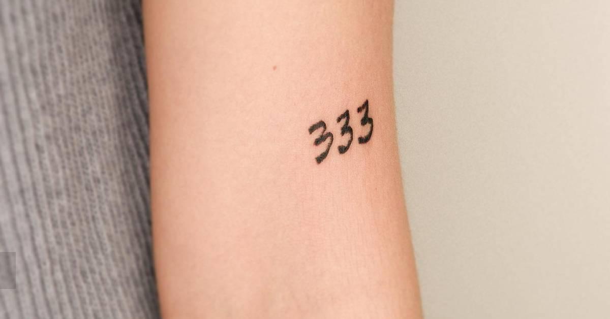 Crayon effect "333" tattoo located on the upper arm.