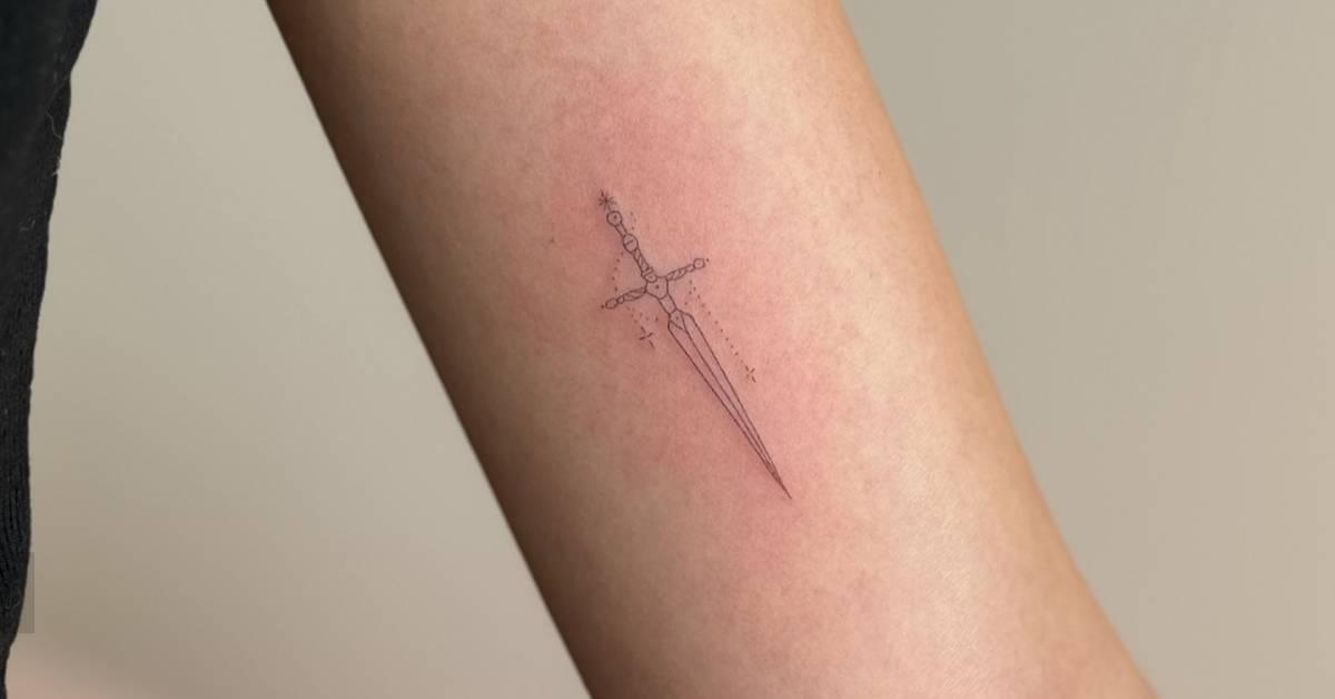 Fine line style dagger tattoo placed on the inner arm.