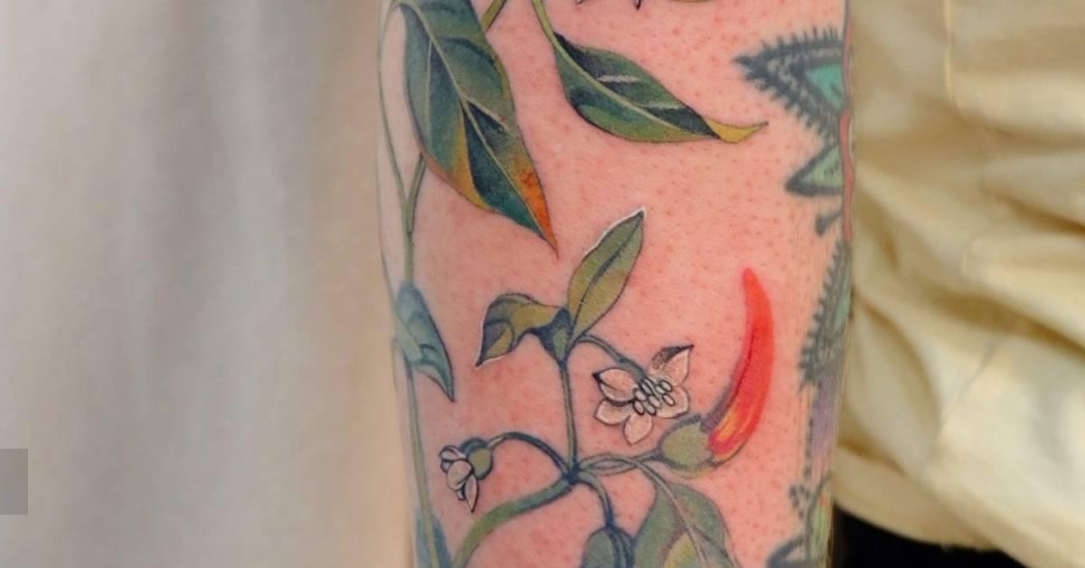 Red chili peppers tattoo located on the forearm,