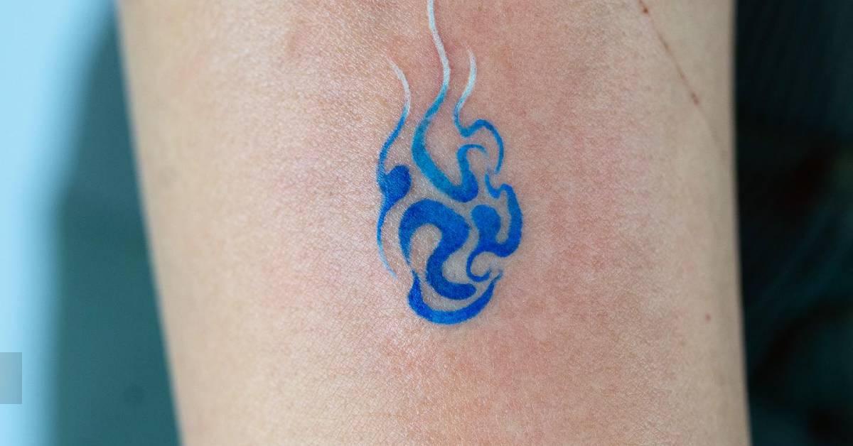 Blue flame tattoo located on the forearm, watercolor