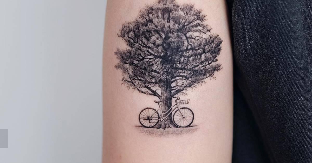 Tree and bicycle tattoo located on the tricep,