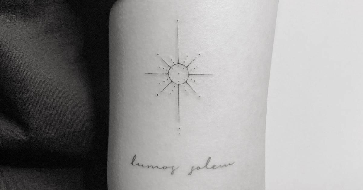 Fine line style sun tattoo placed on the tricep.