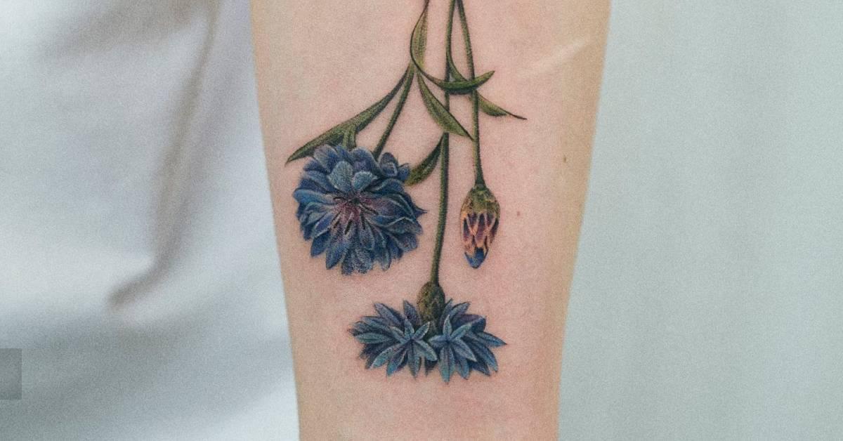 Watercolor style cornflower tattoo located on the inner