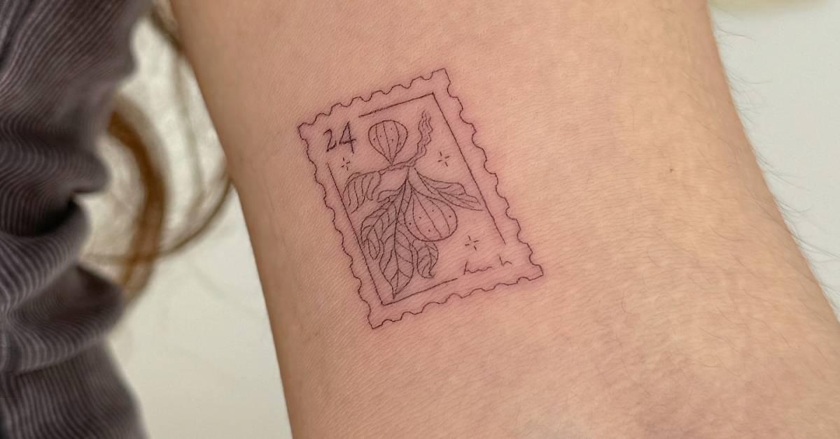 Fig stamp tattoo located on the bicep, fine line style.