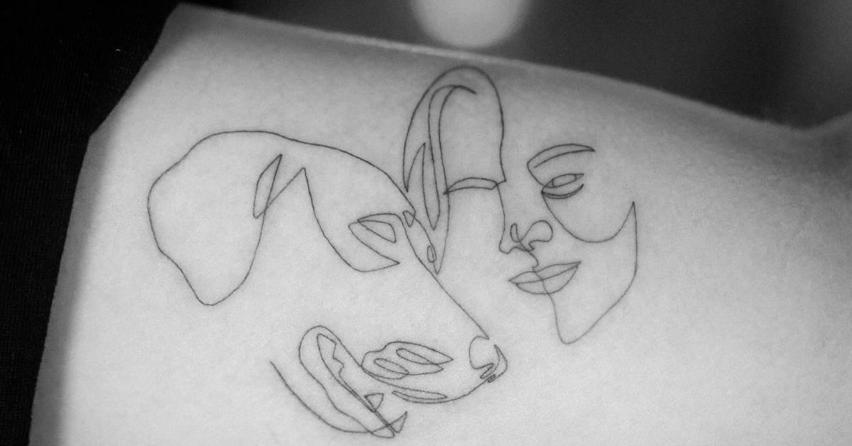 One line woman and dog tattoo located on the inner arm.