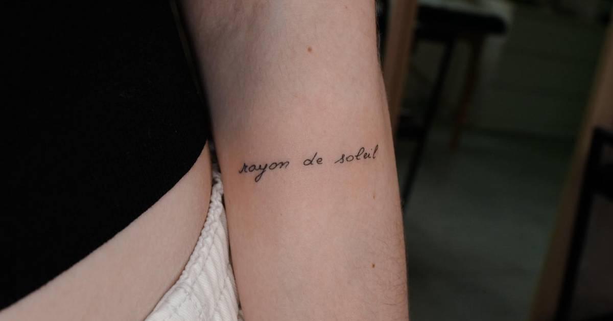"Rayon de soleil" tattoo handwritten on the forearm.