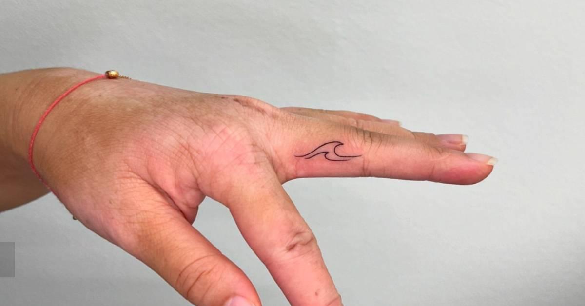Minimalistic waves tattooed on the finger.