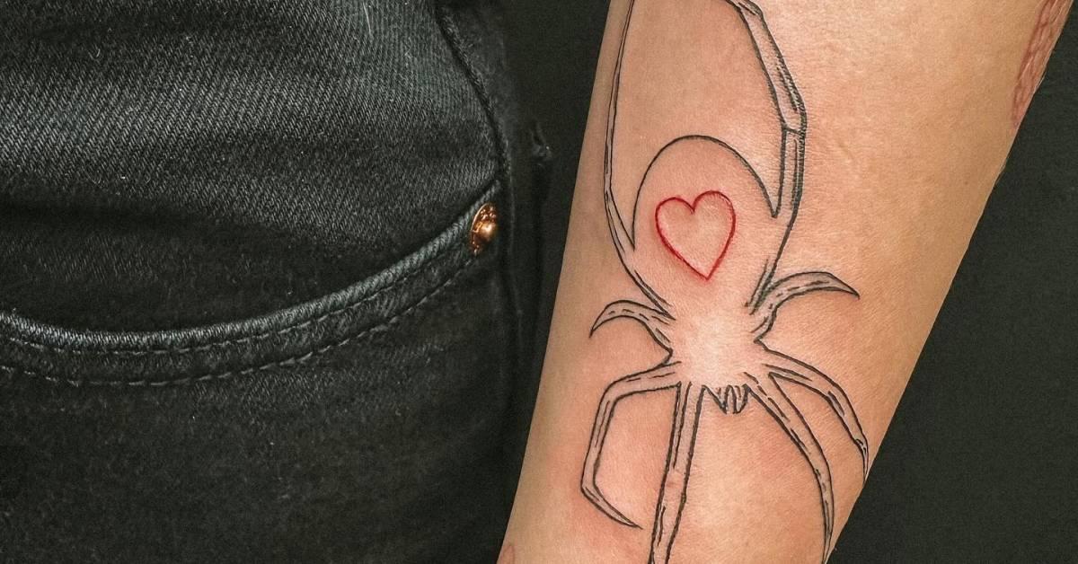 Fine line style spider tattoo located on the forearm.