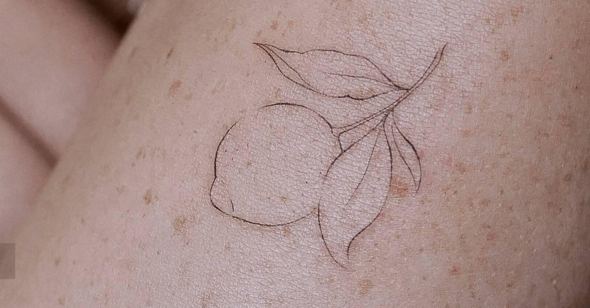 Fine line style lemon tattoo placed on the forearm.