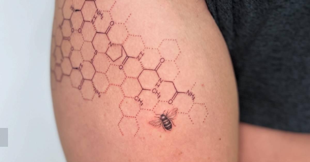 Honeycomb and Oxytocin molecule tattooed on the thigh.