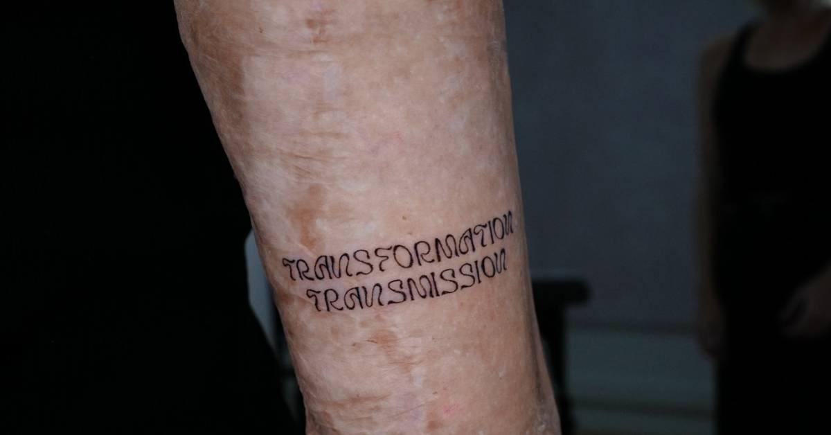 "Transformation transmission" lettering tattoo located