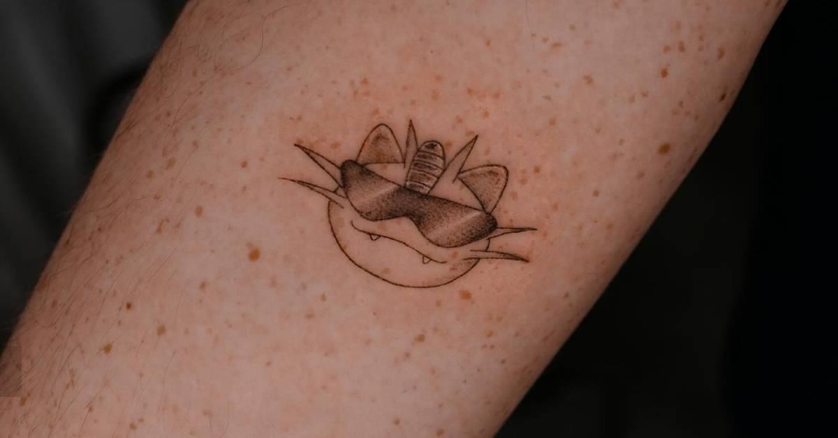 Meowth tattoo located on the inner forearm, cartoon